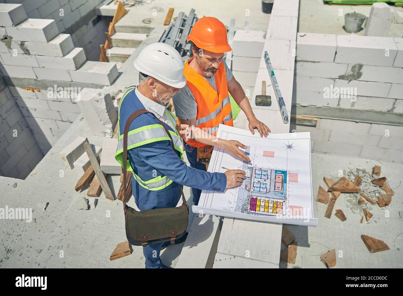 Two adult men discussing a house plan outside Stock Photo - Alamy