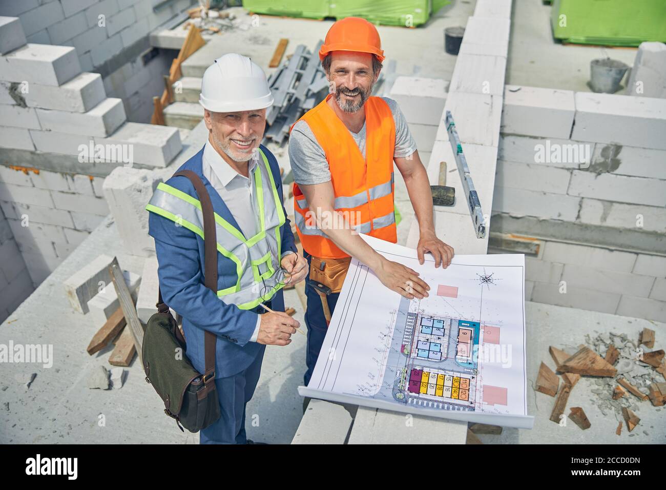 Cheerful senior man and a builder looking upwards Stock Photo - Alamy