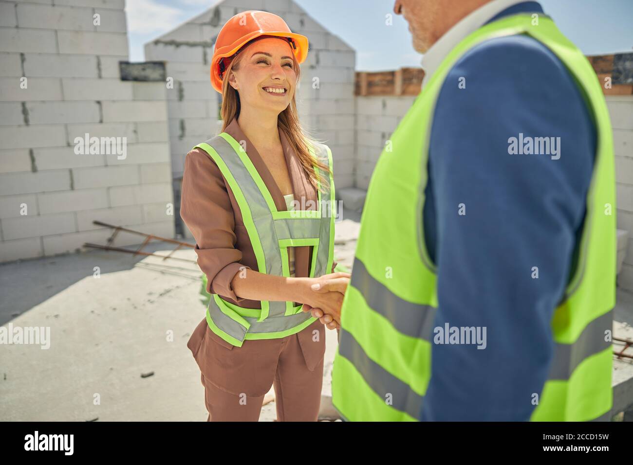 Business lady smiling at a civil engineer Stock Photo - Alamy