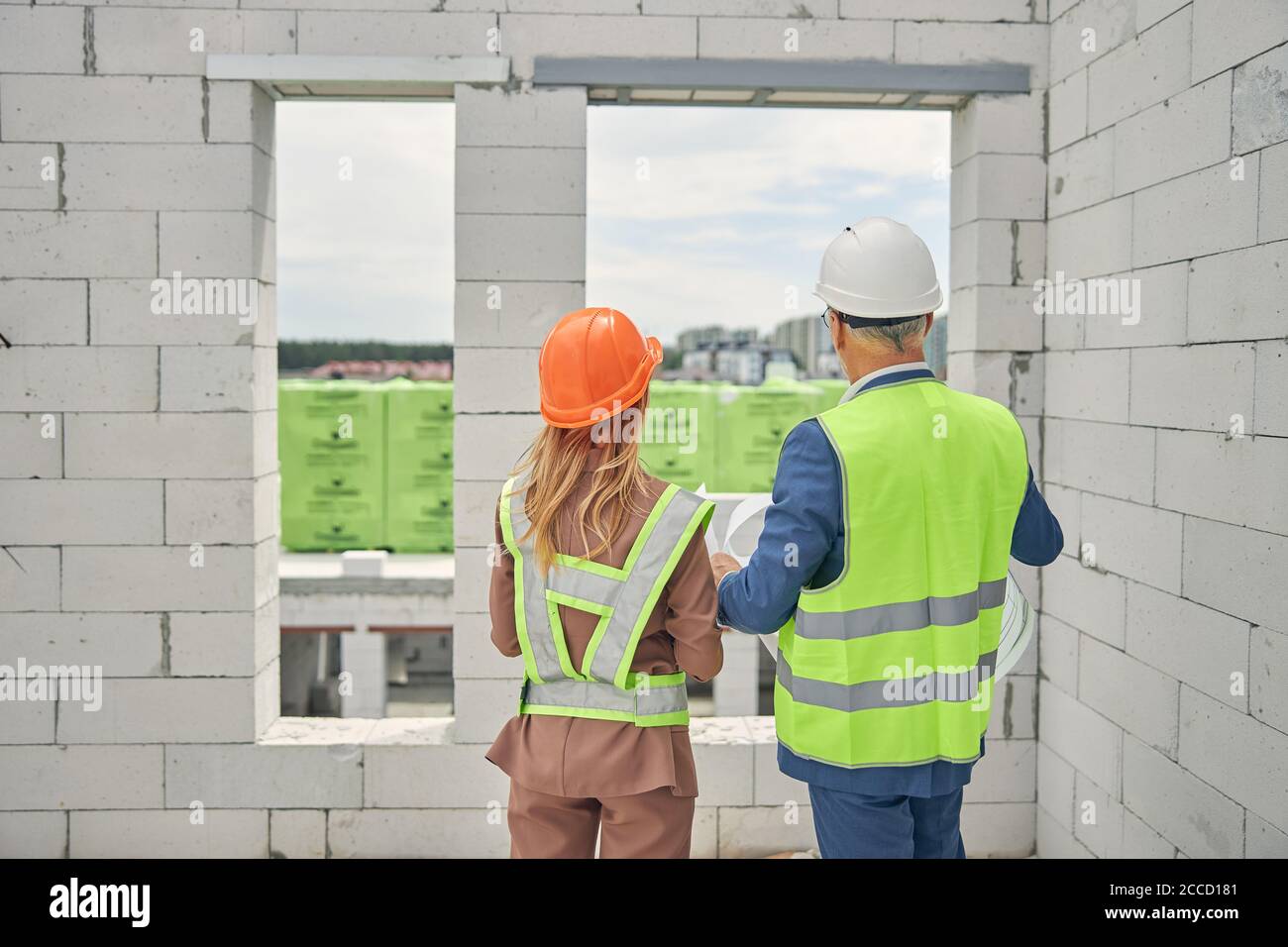Female contractor and a civil engineer inspecting a construction object ...