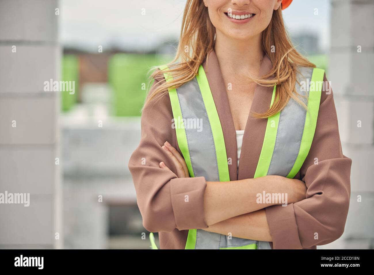 Pleased female engineer wearing a protective helmet Stock Photo - Alamy