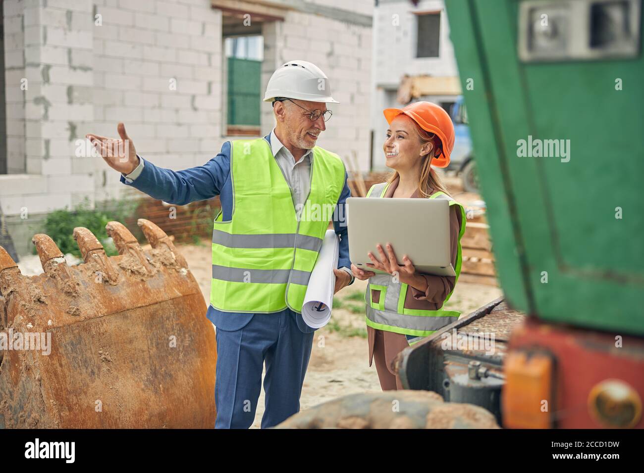 Smiling worker pointing at something in the distance Stock Photo - Alamy