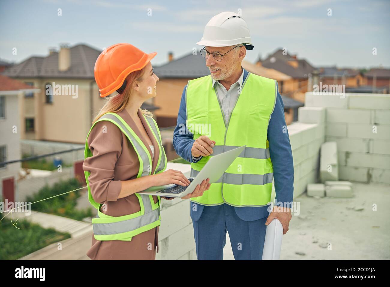 Blonde female contractor smiling at a civil engineer Stock Photo - Alamy