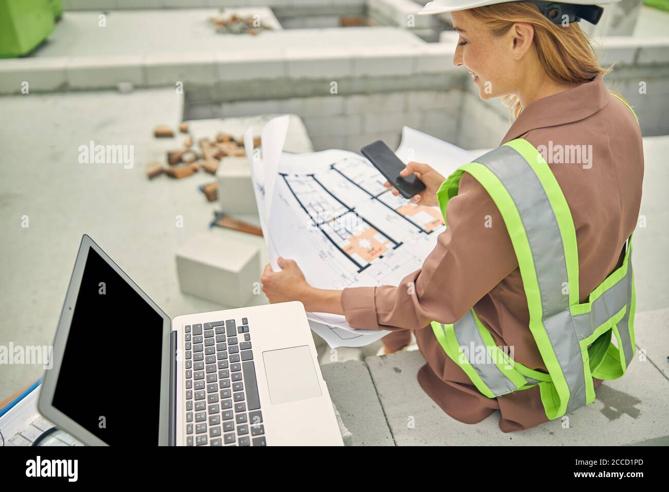 Joyous female engineer holding a technical drawing Stock Photo - Alamy