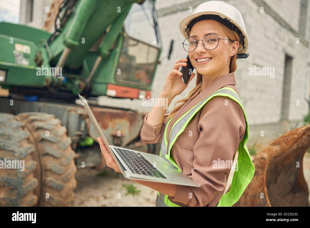 Smiling construction supervisor making a phone call Stock Photo - Alamy