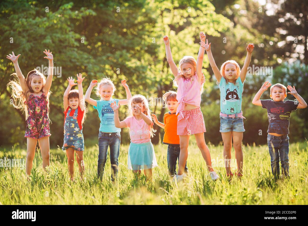 Group of friends running happily together in the grass and jumping ...