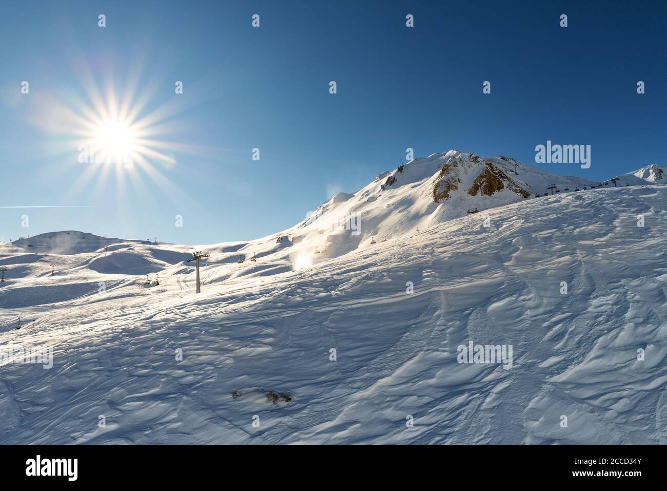 Scenic view of snow covered alpine mountain on bright sunny winter day ...