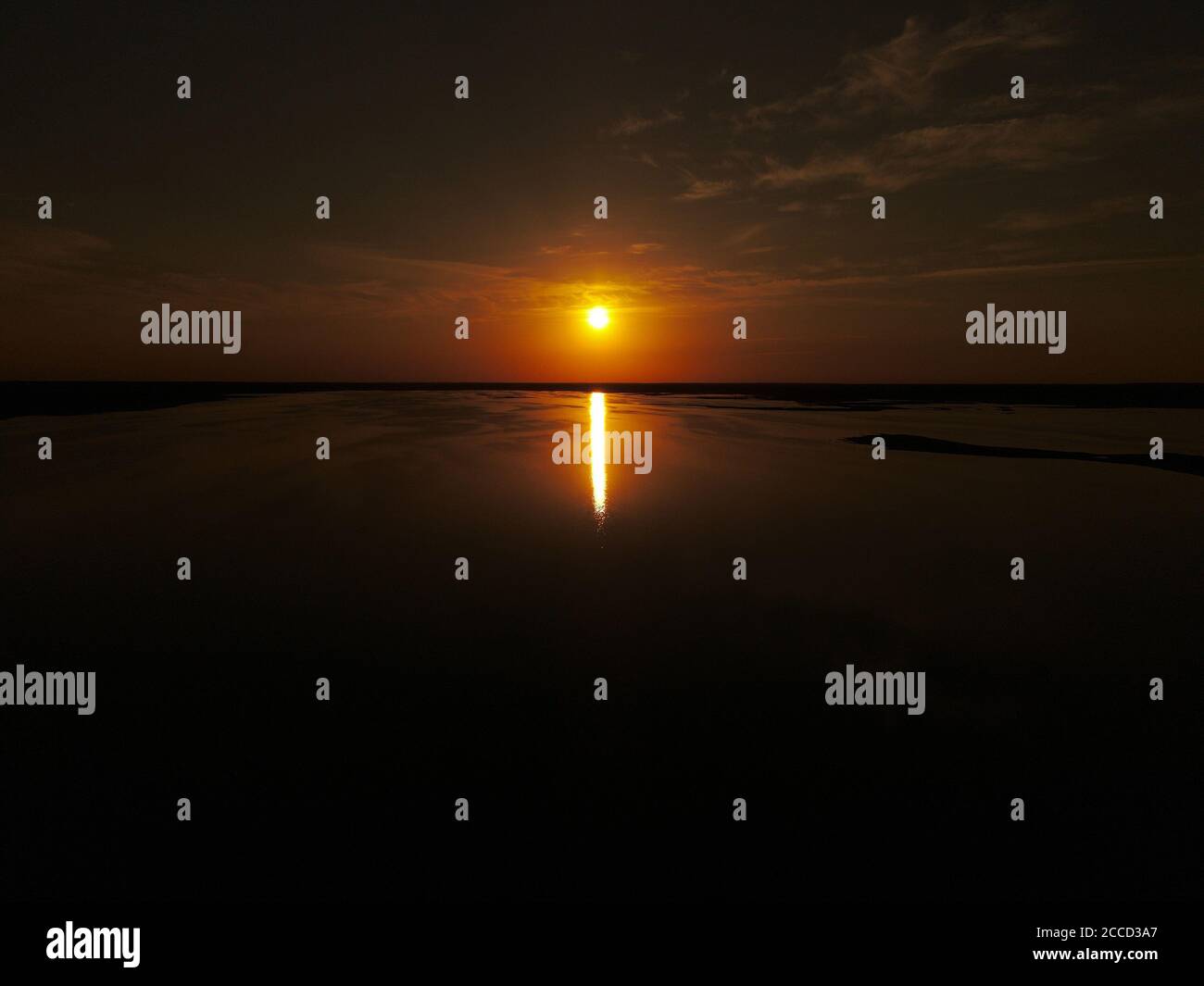 Dark orange sunset on the sea beach Stock Photo - Alamy