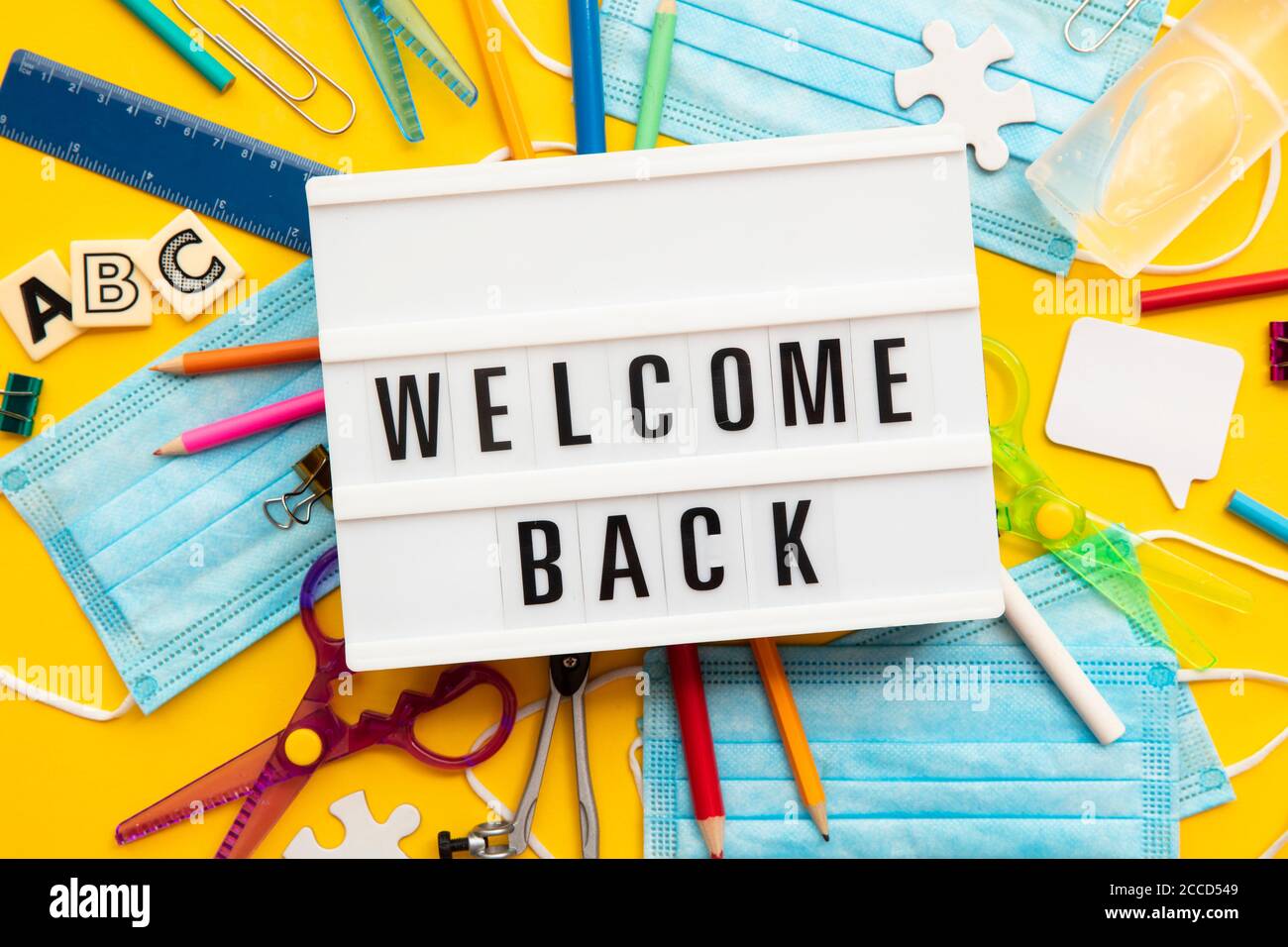 Welcome back lightbox message with school equipment and covid masks ...