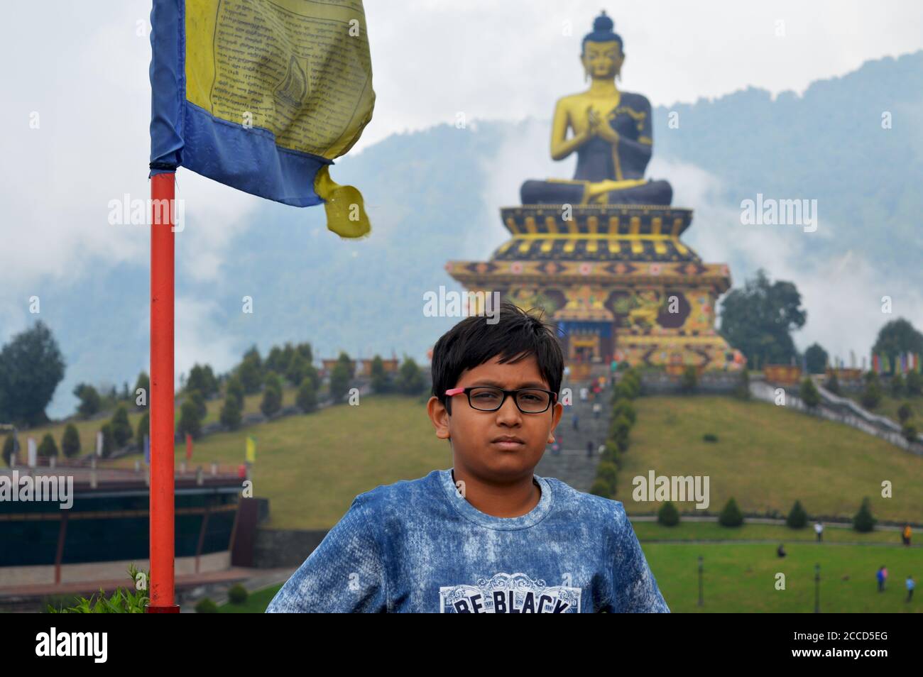 An Indian young boy posing for picture in front of the Buddha Statue of ...