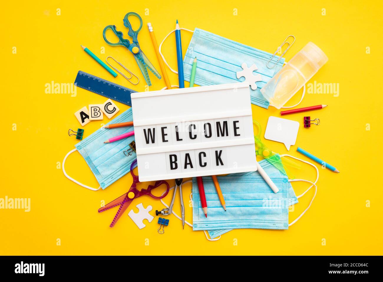 Welcome back lightbox message with school equipment and covid masks ...