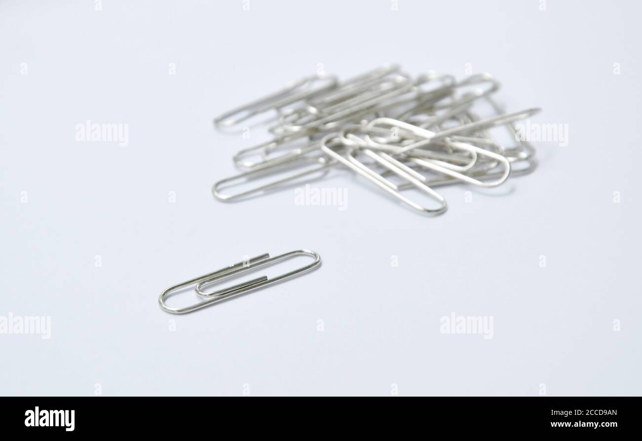 Silver paper clip on white background Stock Photo - Alamy