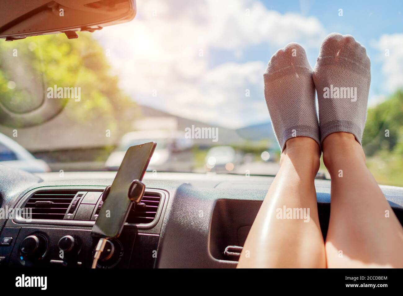 Woman put legs on car desk in salon. Passenger feels free and happy on ...