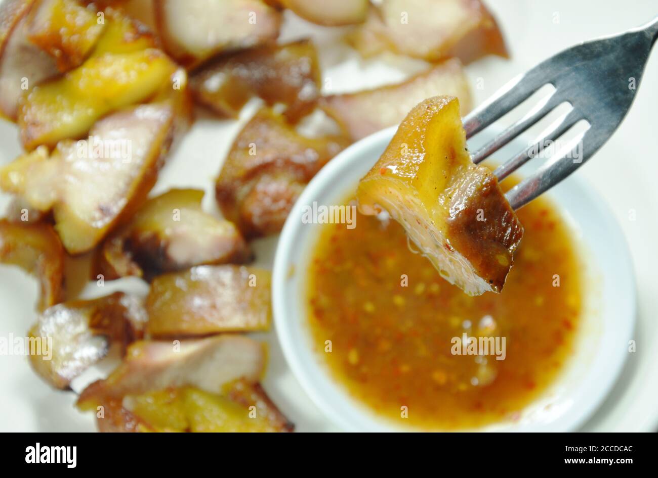 roasted pork ear slice dipping with spicy sauce on plate Stock Photo ...
