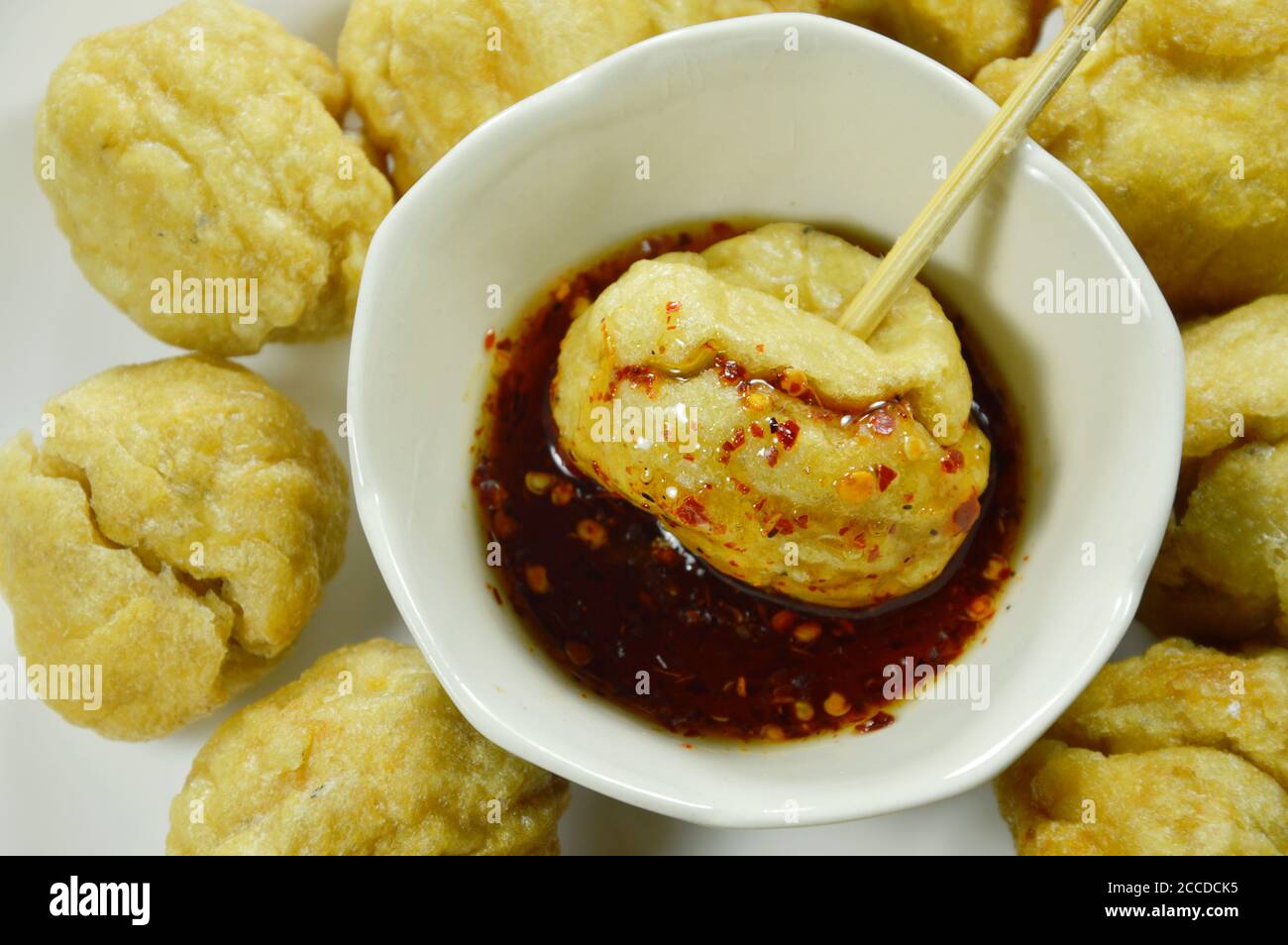 crispy fried fish ball stabbing in wooden stick dipping spicy and sweet ...