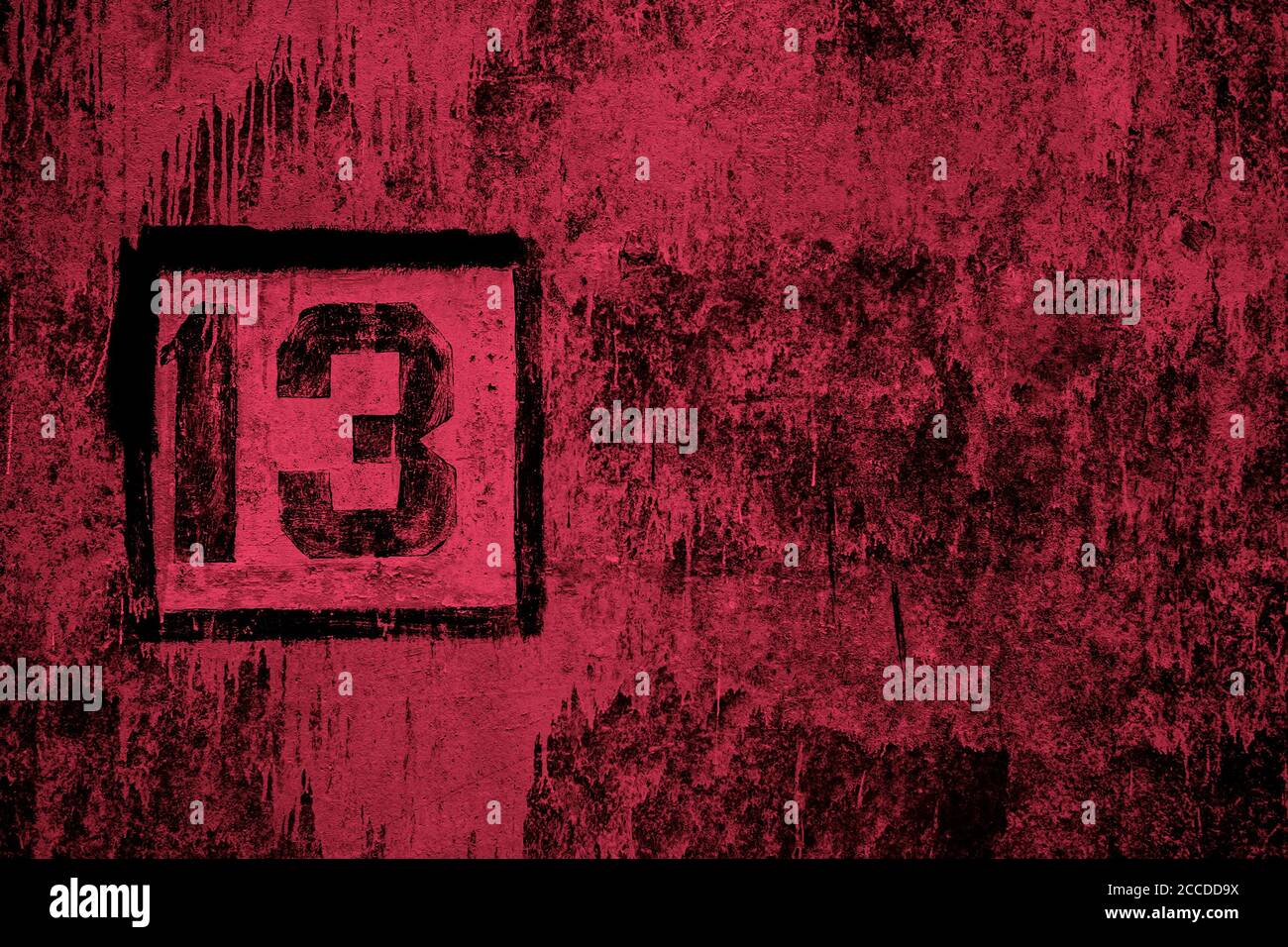 number 13 painted with black stencil on stained red concrete wall Stock ...
