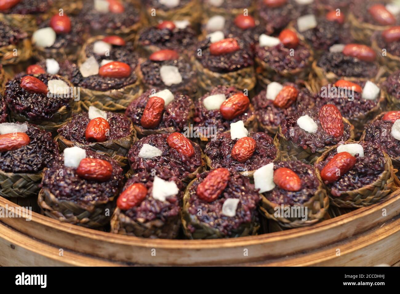 close up purple rice cakes in bamboo steamer. traditional Chinese snack ...