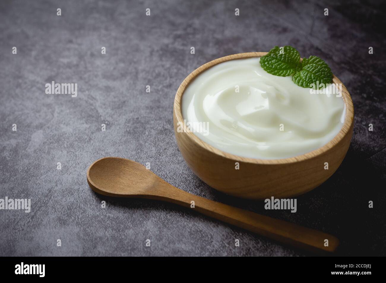 Plain Yogurt in wooden bowl on table Stock Photo - Alamy