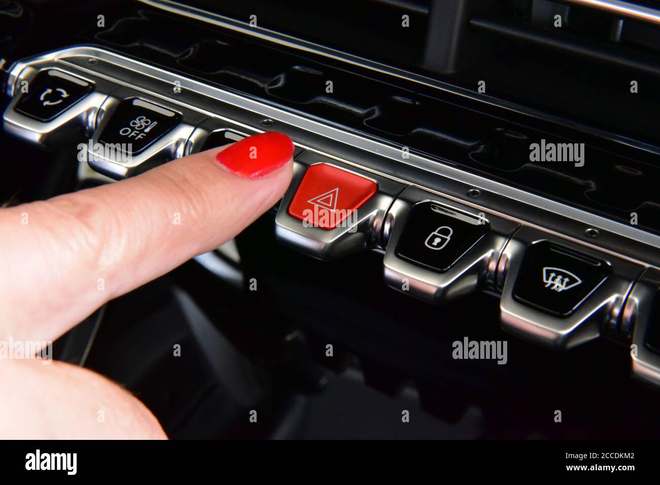 Woman pressing red triangle car hazard warning button. Female finger ...