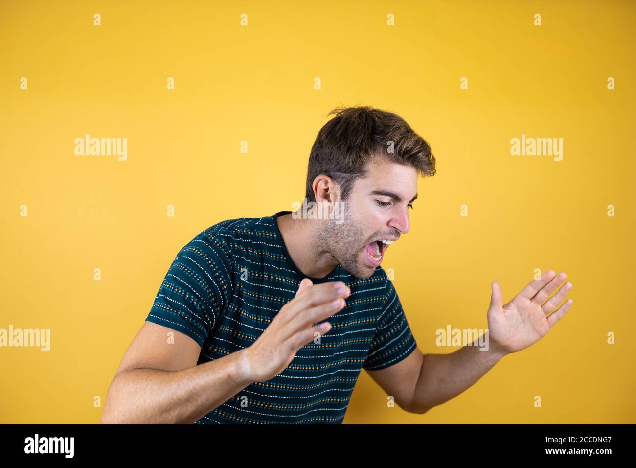 Young fitness man over yellow isolated background shouting and ...