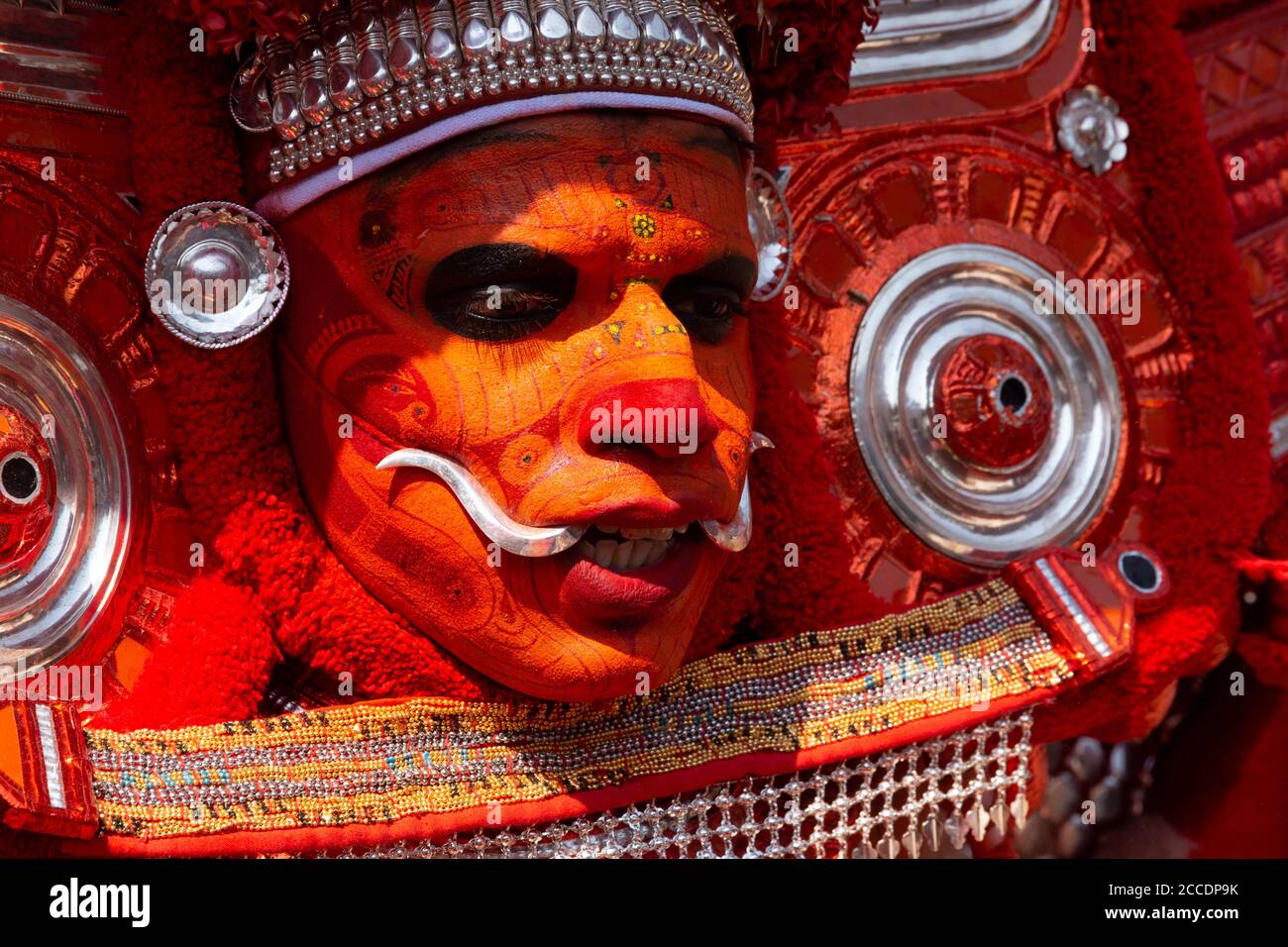 Traditional Theyyam performer adorned in elaborate costume and makeup ...
