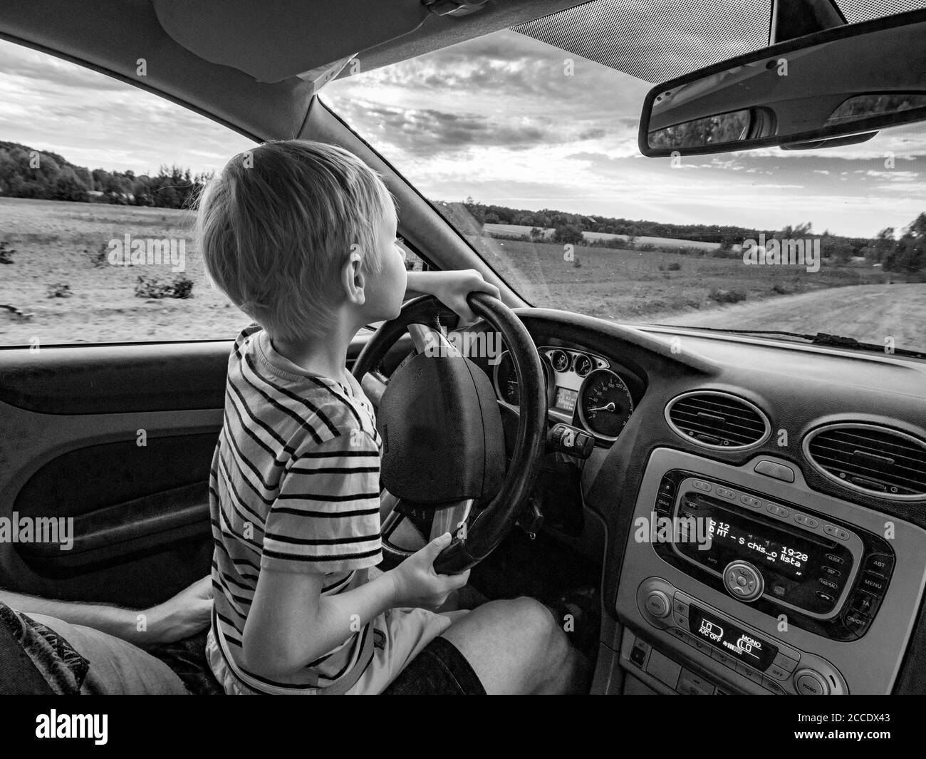 Little caucasian boy drives a car sitting on his daddy's lap Stock ...