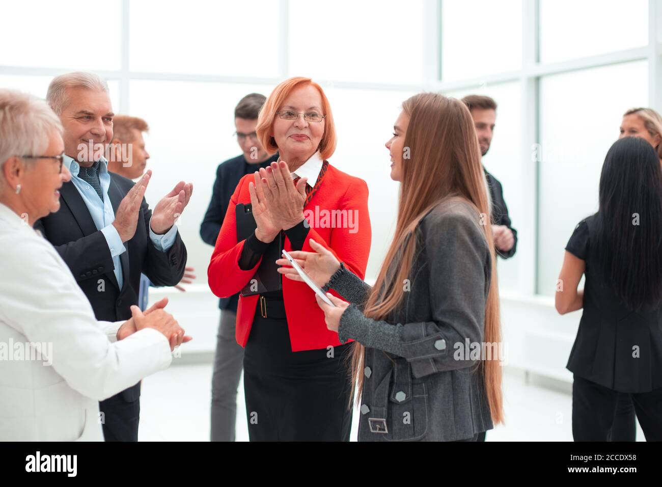 Happy business people sitting around Stock Photo - Alamy