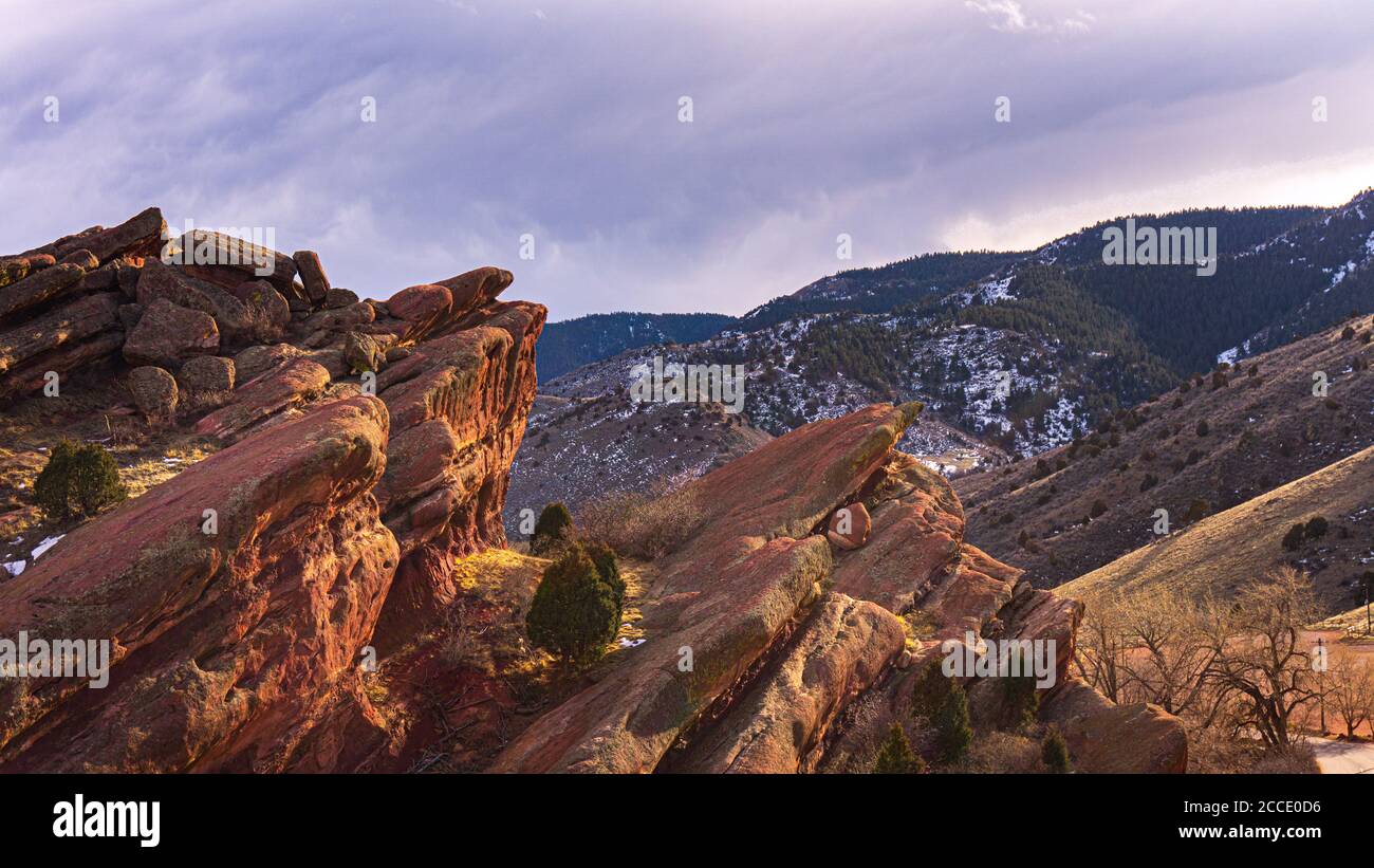 red rocks in sunlight with snow mountains in background Stock Photo - Alamy