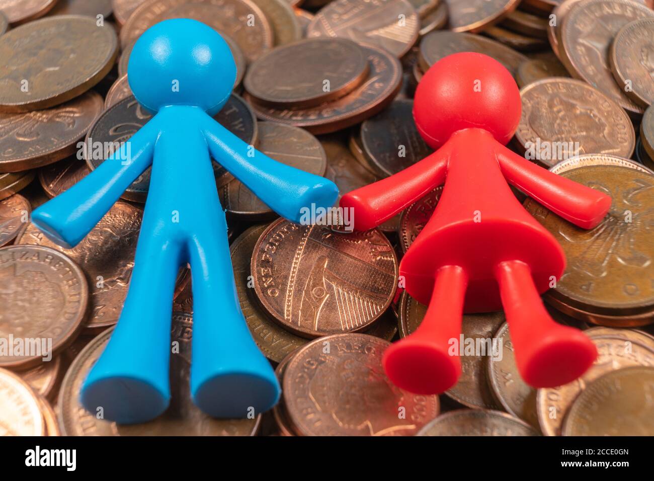 Small red and blue plastic toy cople. Plastic figures lying on a pile ...