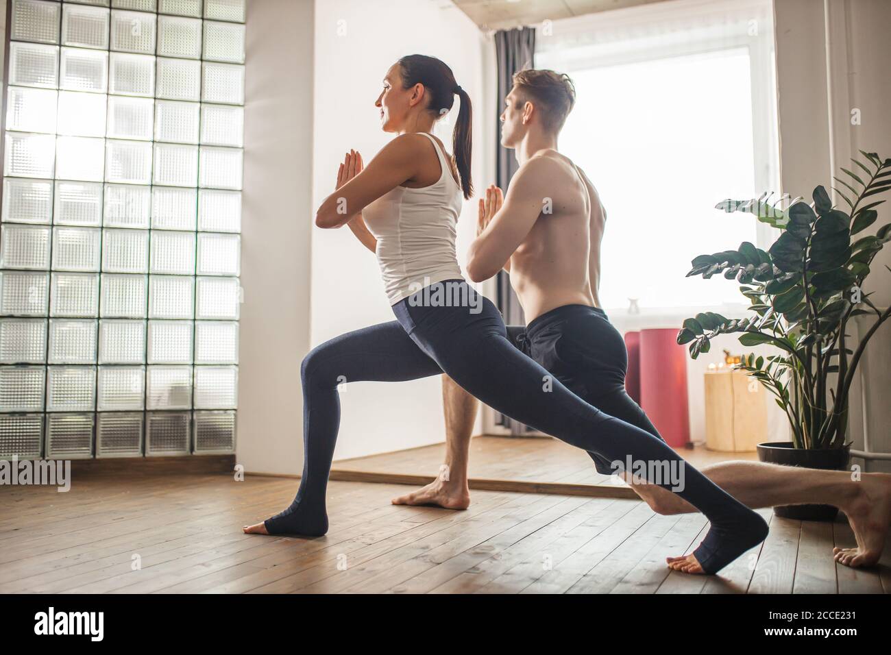 young caucasian couple is doing fitness training at home. practicing ...