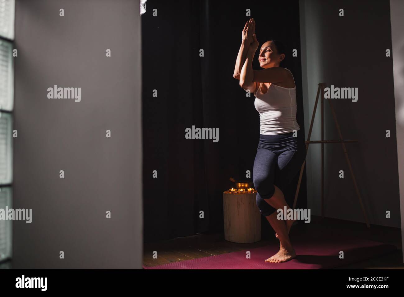 slender caucasian woman stand in yoga pose, try to keep balance, with ...