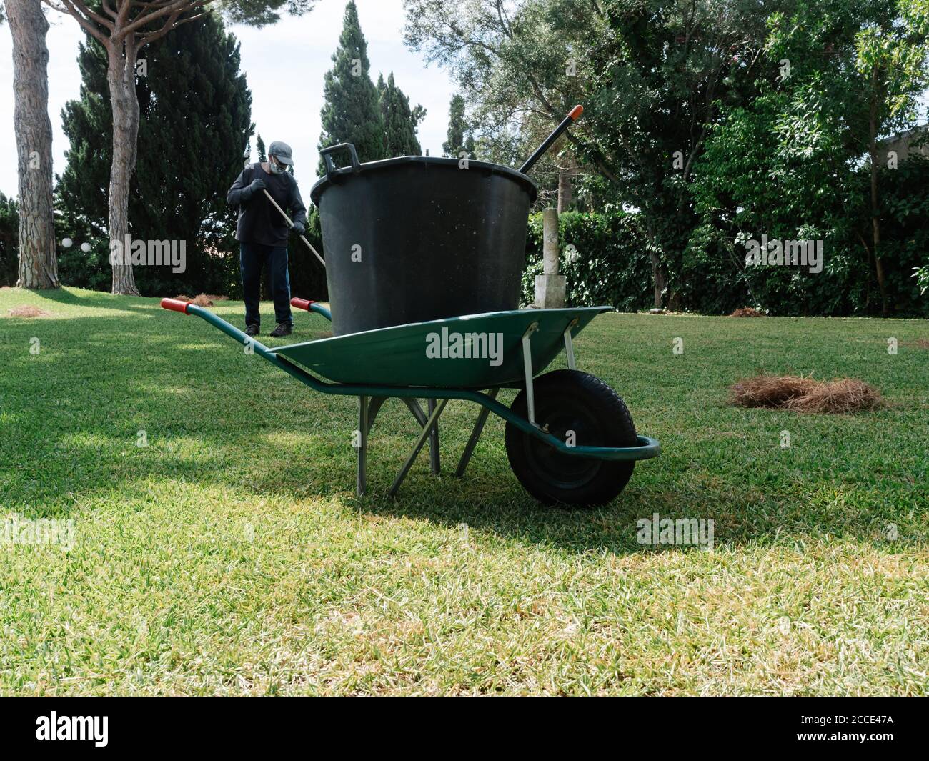 Iron wheelbarrow carrying bucket of grass cut from a garden Stock Photo ...
