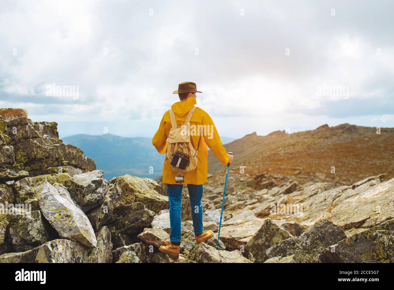 motivated hiker at the top of a rock with backpack enjoy autumn day ...