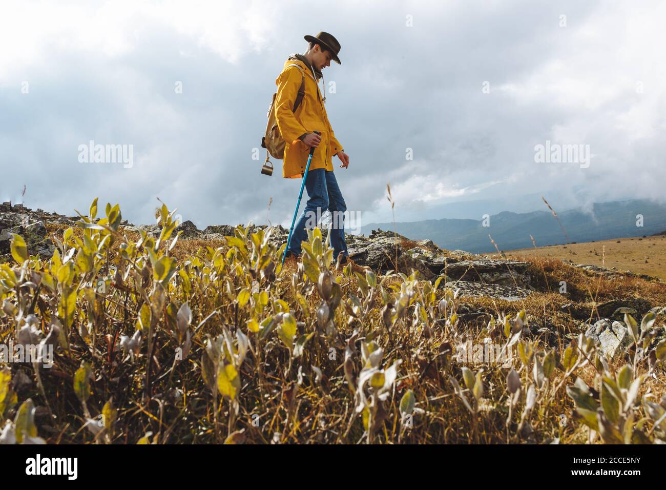 tired traveller discending the hill, going down. full length side view ...