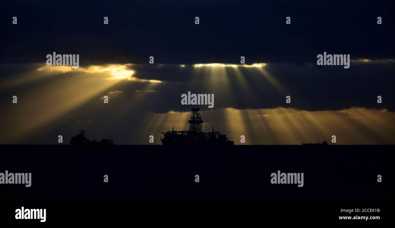 Sunrise on the sea with beams of light through the clouds and backlit ...