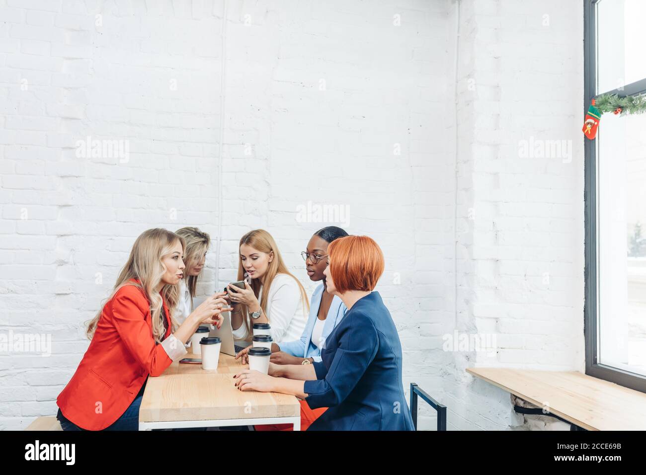 Team work process. Multiracial group of young women collaborating in ...