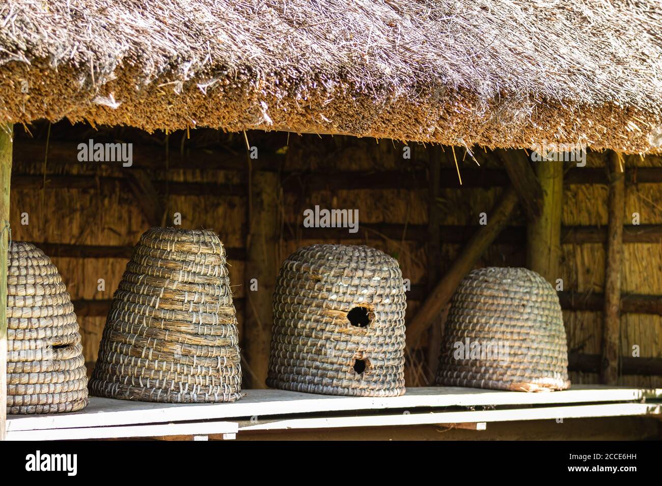 Row of empty old traditional woven wicker beehives on a shelf Stock ...
