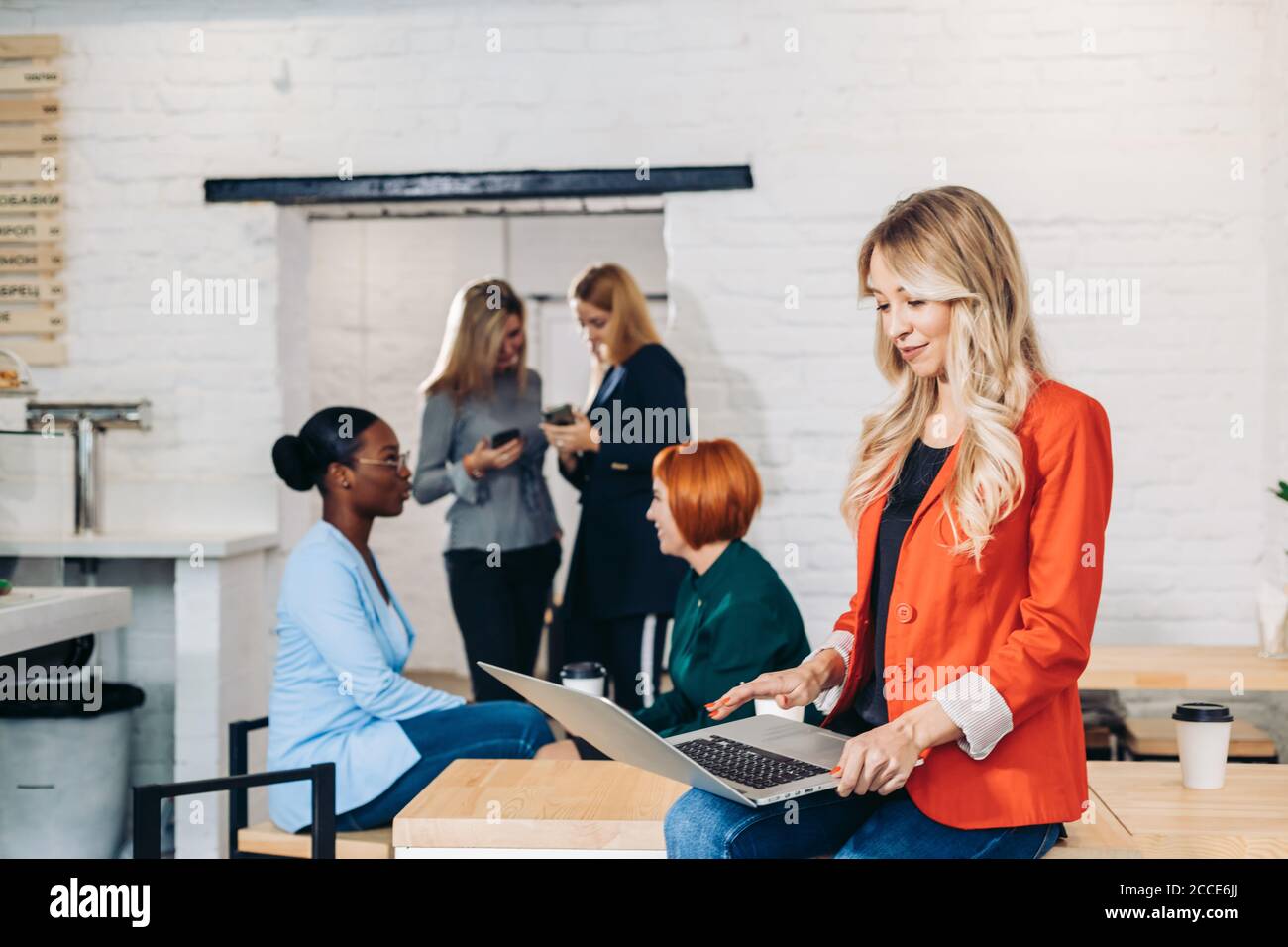 Confident caucasian woman using laptop computer and looking at camera ...