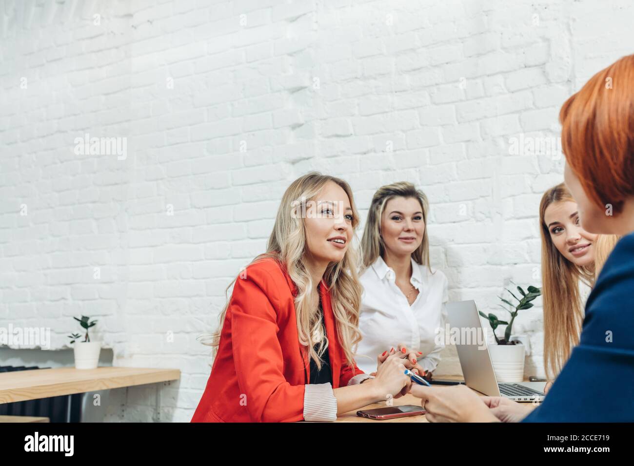 Attractive red-haired female teacher speaking to a group of young ...