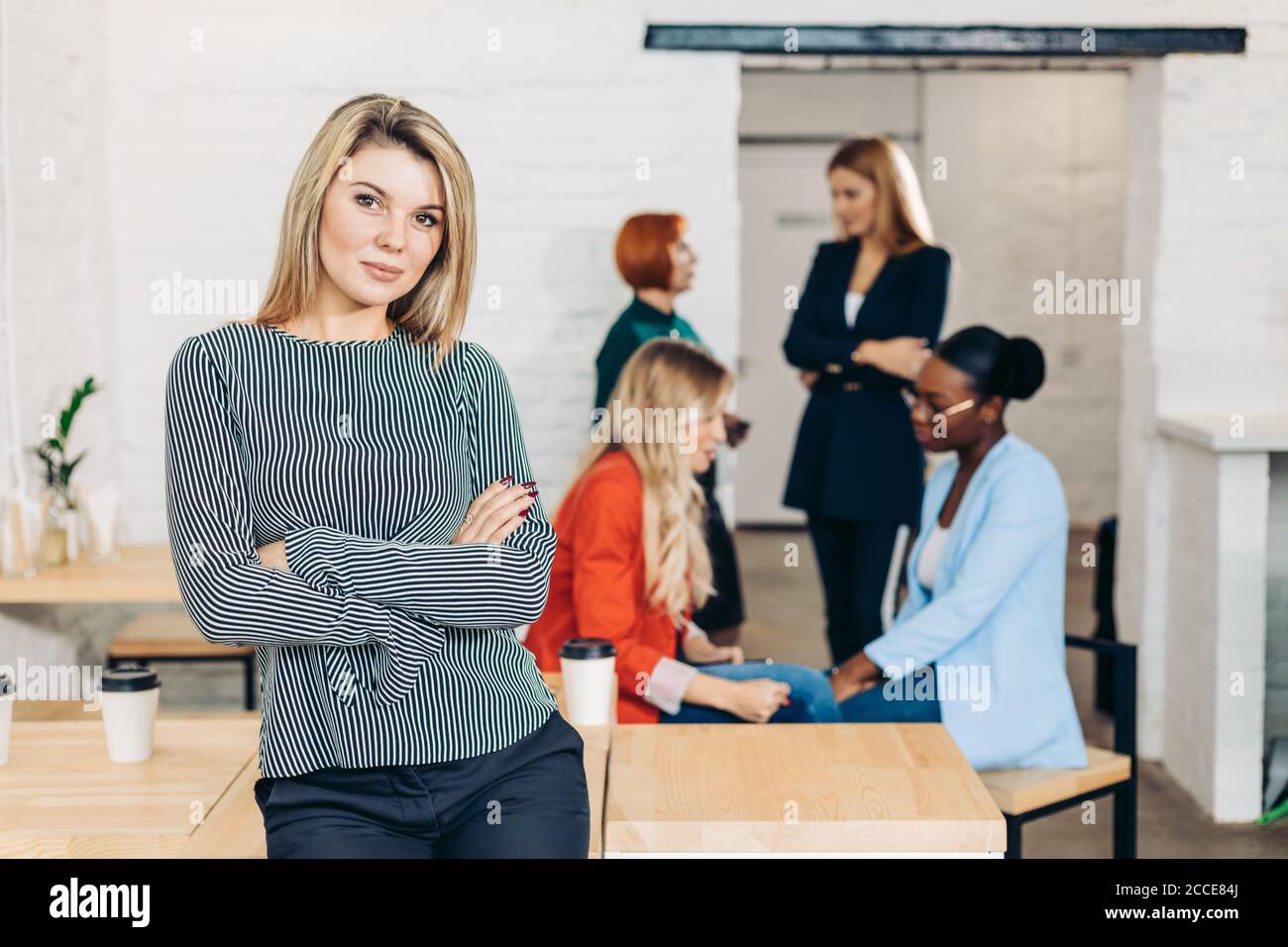 Indoor shot of pleasant-looking female copywriter with long blonde hair ...