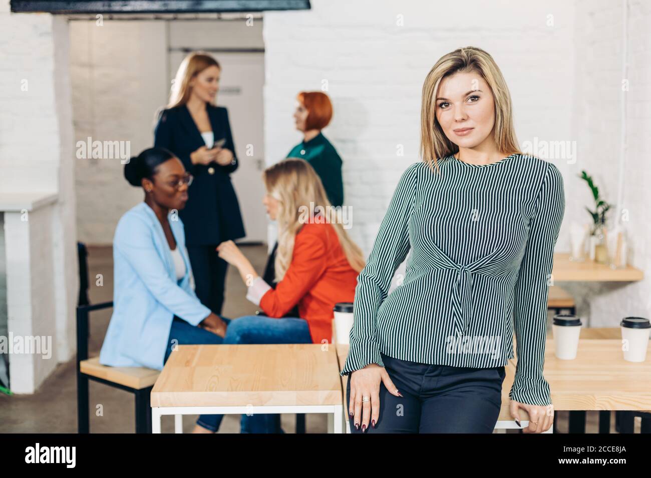 Attractive blonde female accountant or economist in casual wear looking ...