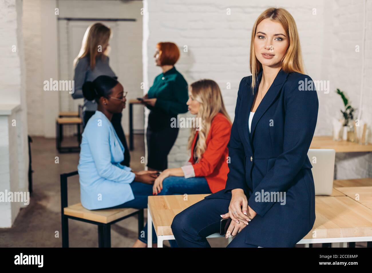 Content satisfied blonde female secretary in trendy formal wear posing ...