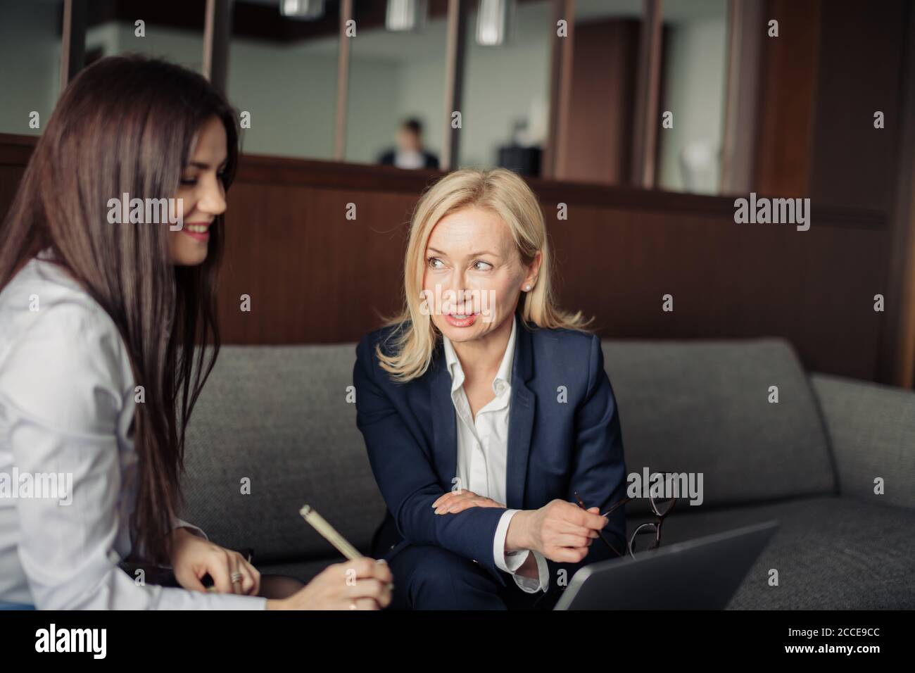 Two caucasian female coworkers working together on business project ...