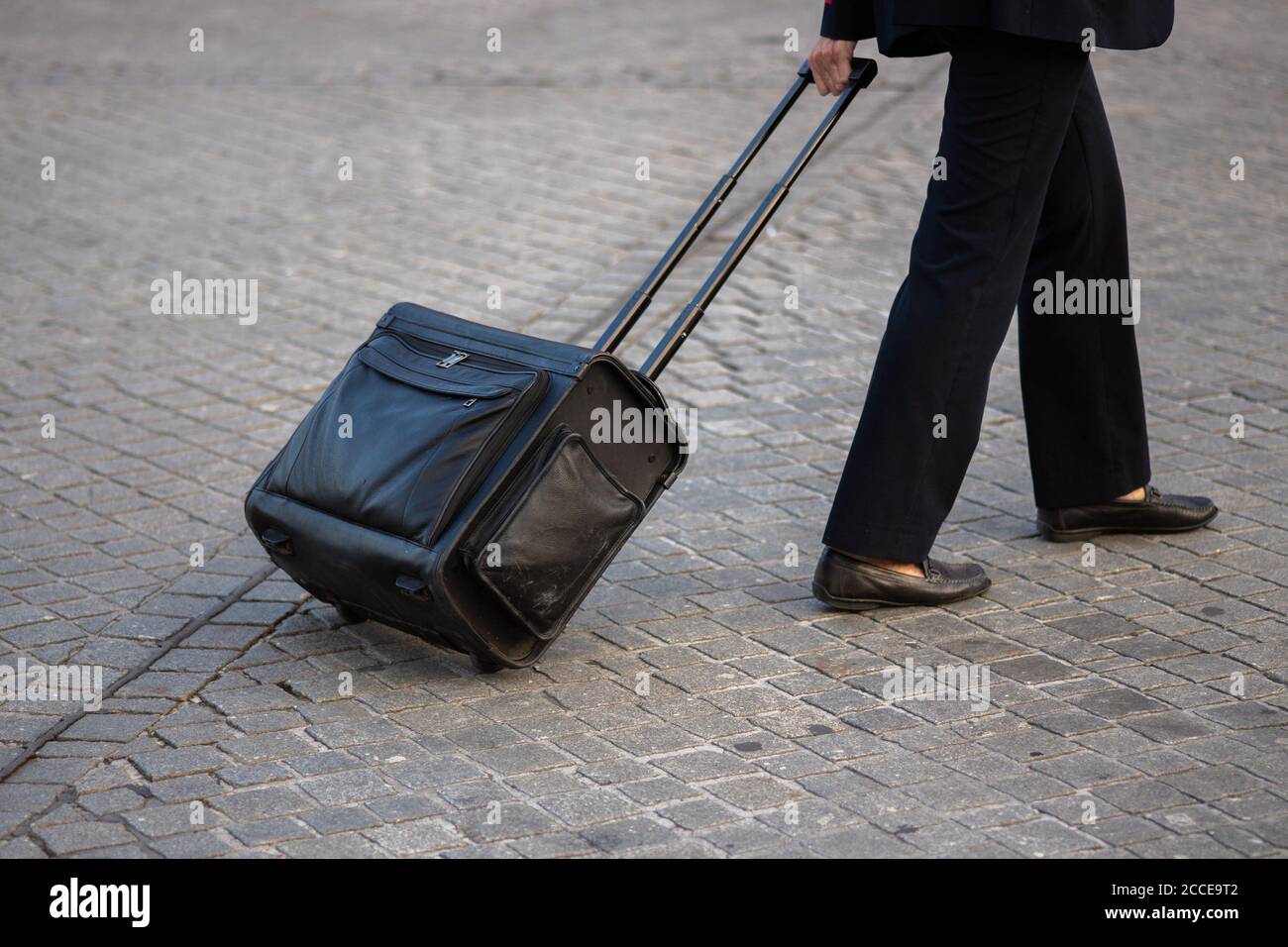 closeup of the legs of a female professional with work suit dragging a ...