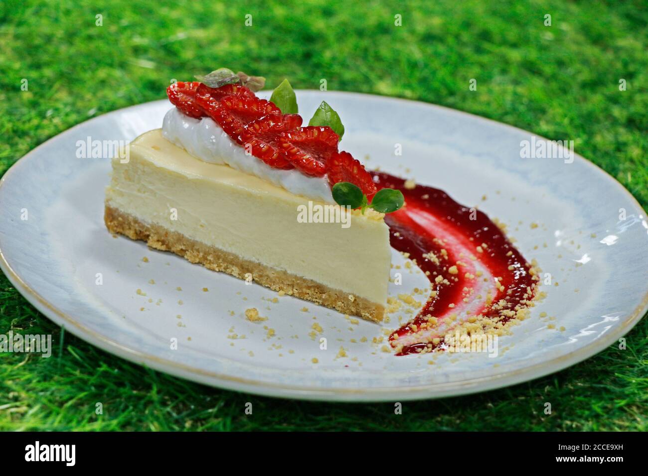 cheesecake portion with raspberry and crumble on a green background ...