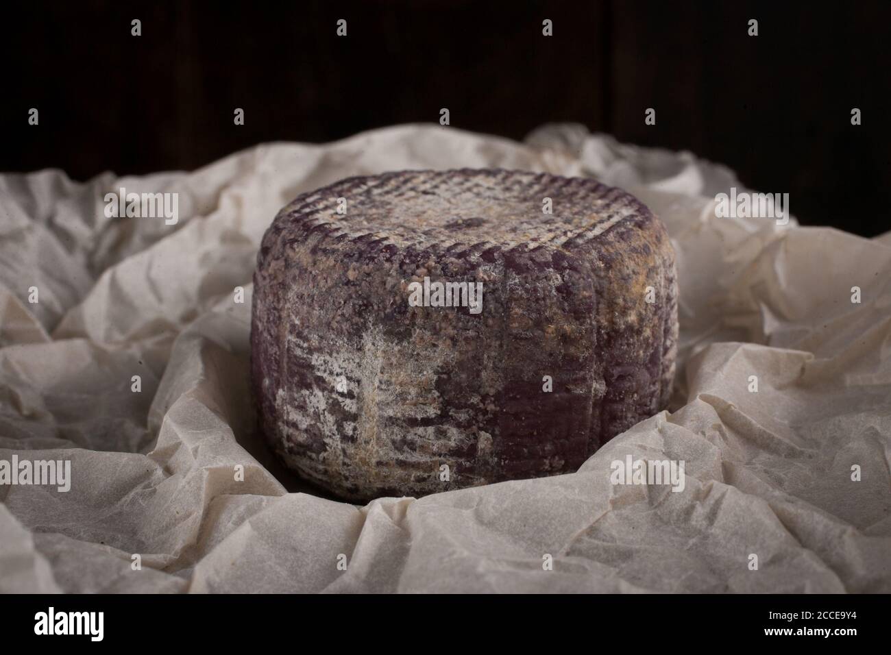 Close up of soft French cheese with purple crust on paper Stock Photo ...