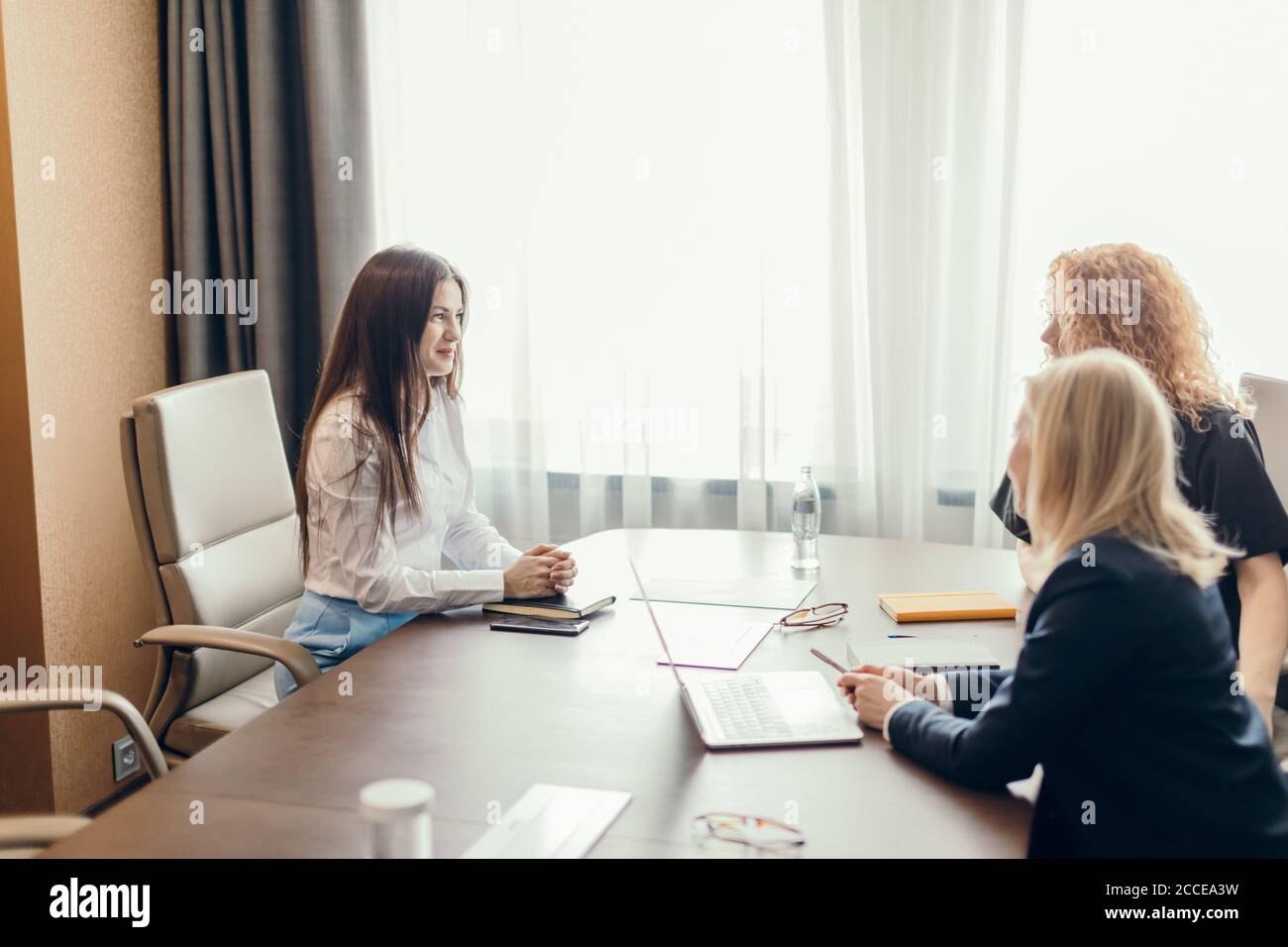 Two female human resources managers conducting job interview with woman ...
