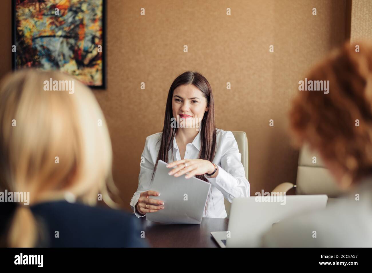 Two female human resources managers conducting job interview with woman ...