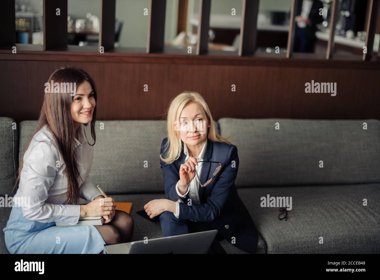 Brunette girl arranging meeting with female lowyer or tax advisor at ...