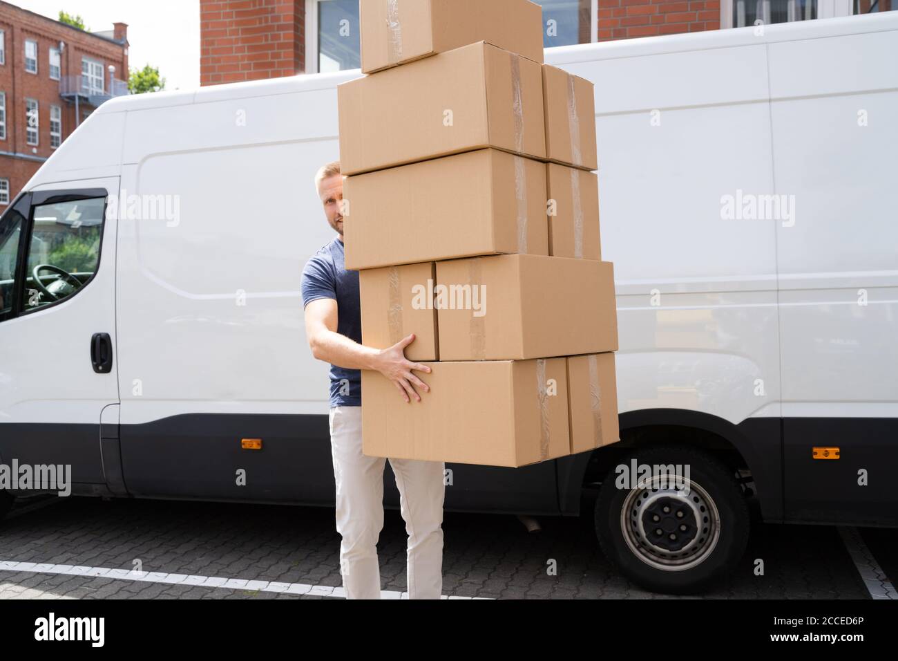 Movers Carrying Heavy Large Box Stack Near Truck Stock Photo - Alamy